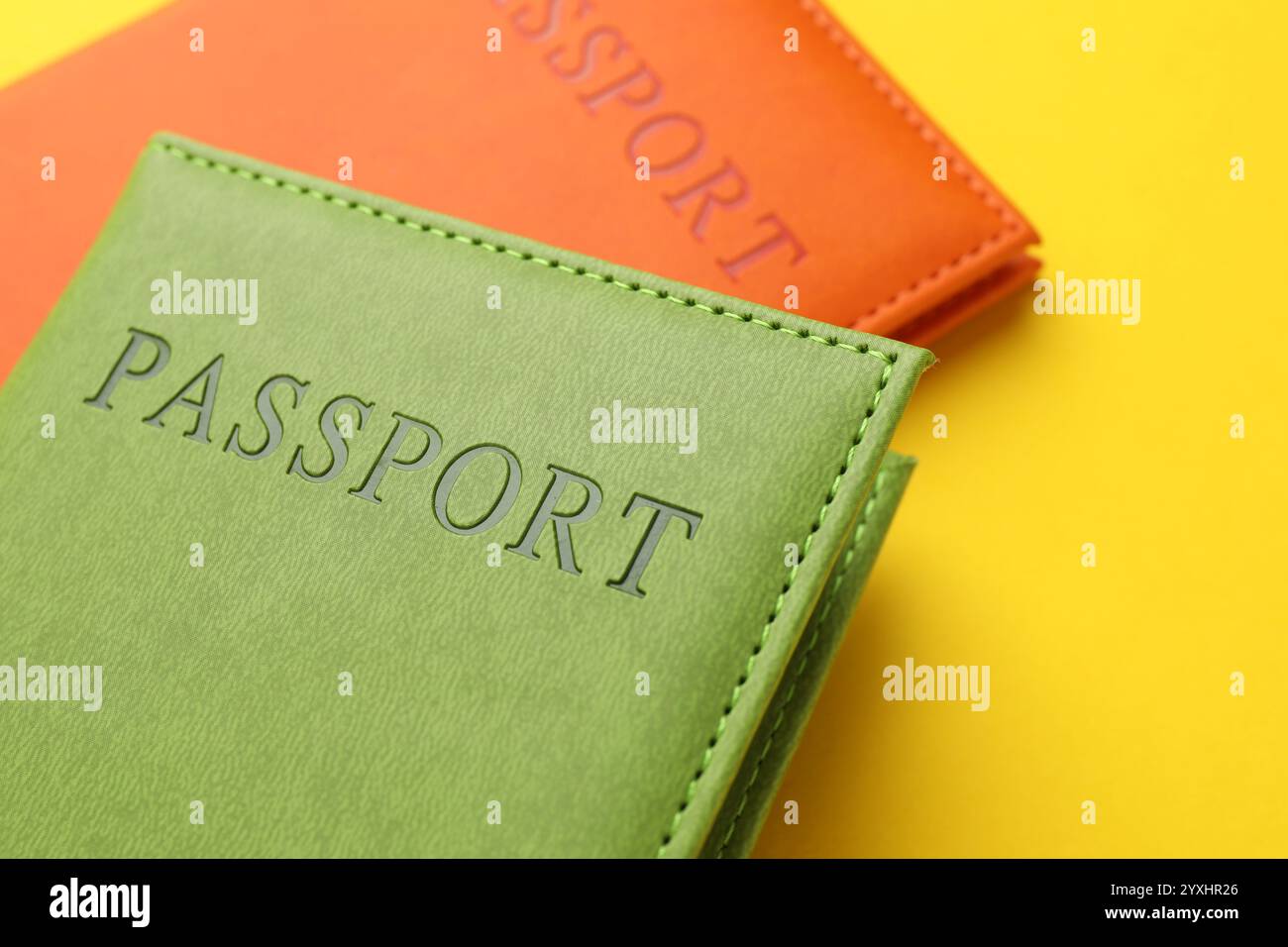 Passports in color covers on yellow background, closeup Stock Photo - Alamy