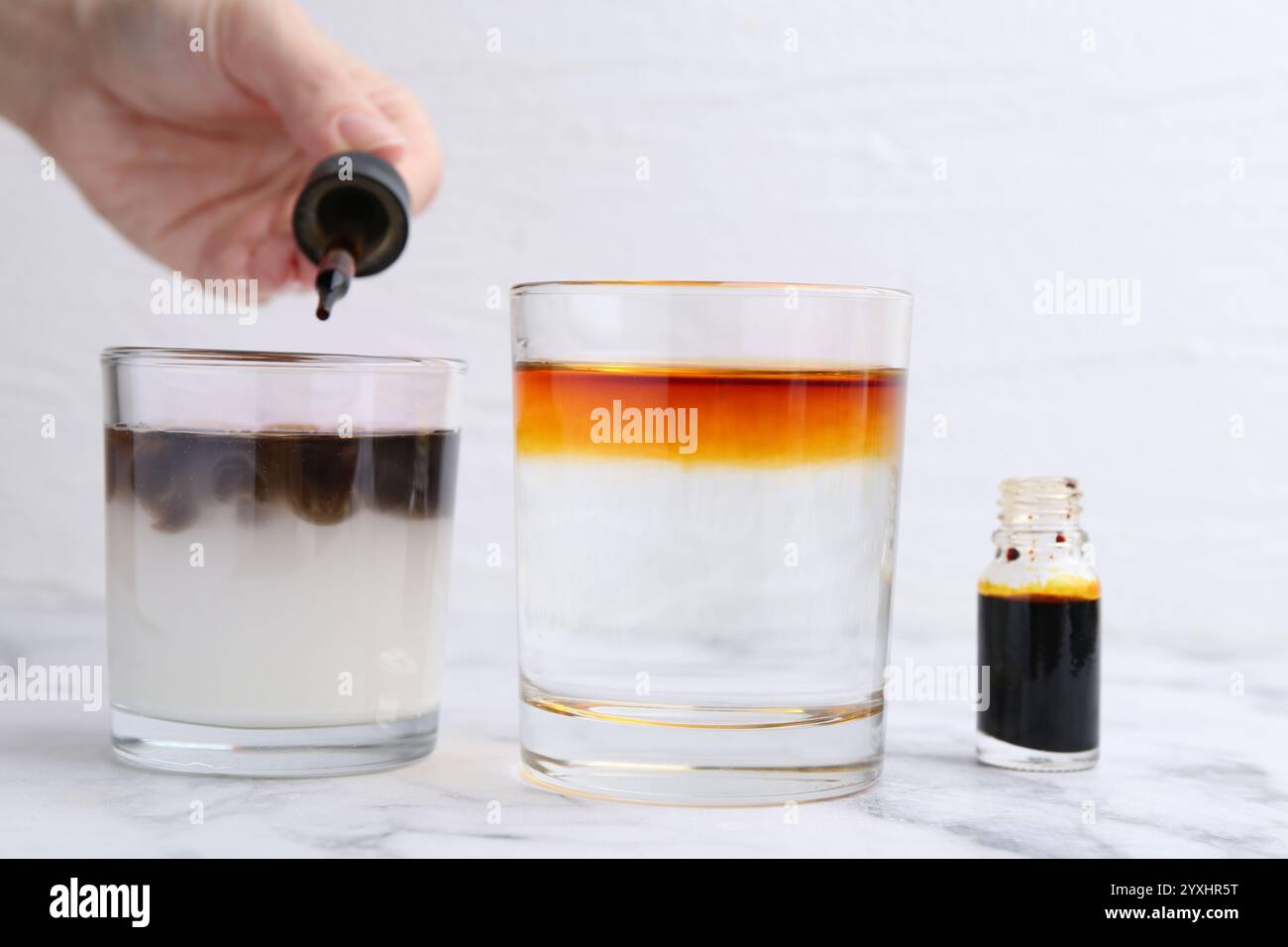 Iodine starch test. Woman dripping aqueous iodine into glass of water ...