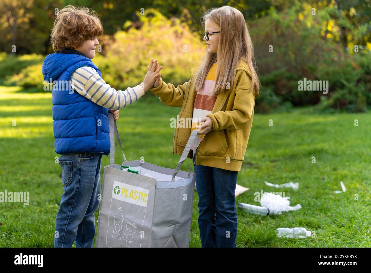 Caucasian kids boy and girl volunteering outdoors cleaning pollution ...