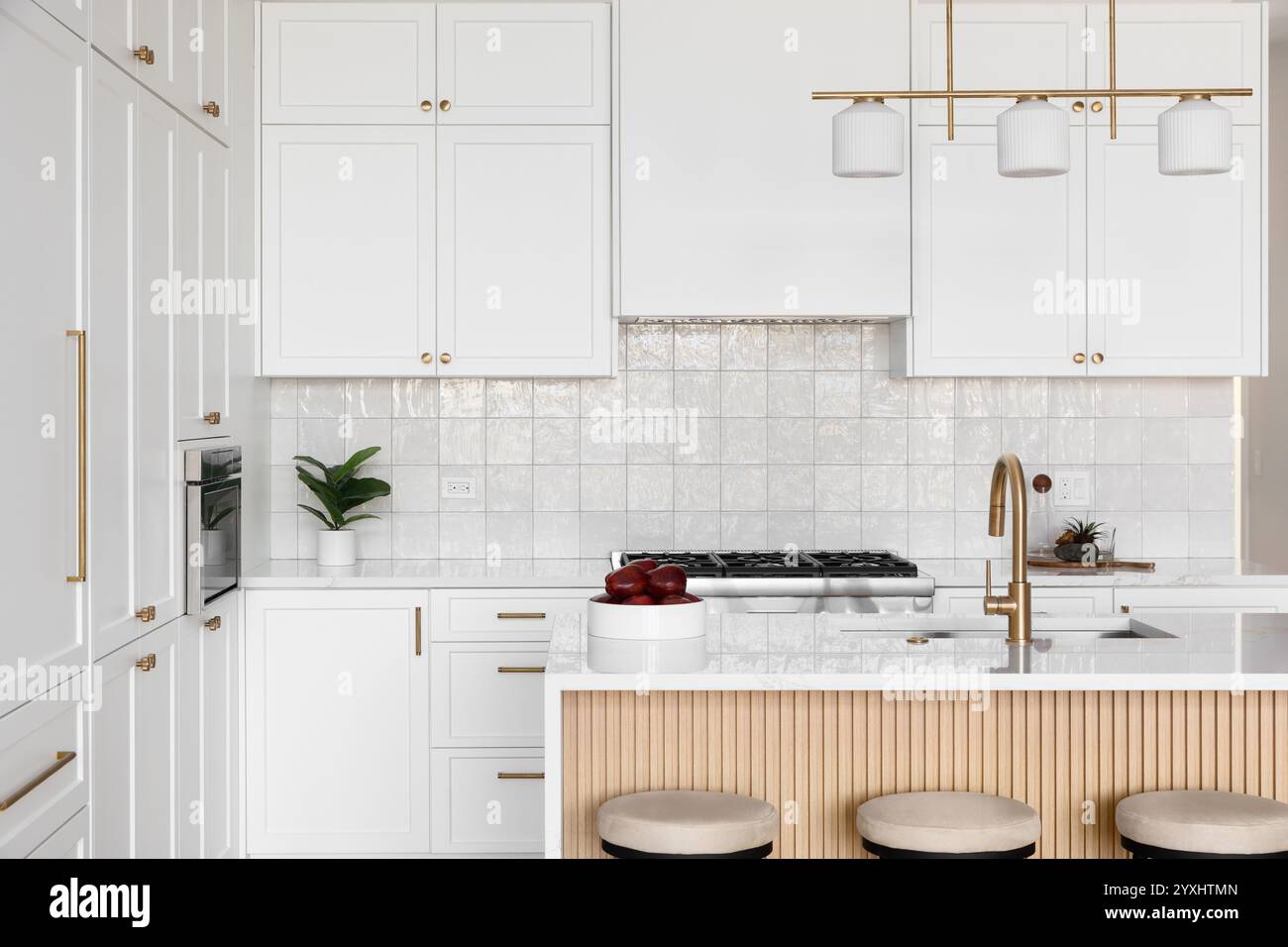 A kitchen detail with white cabinets and square tile backsplash, a ...
