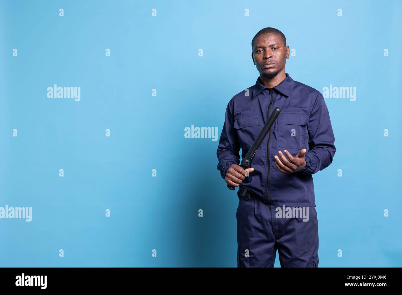 Security agent presenting his baton weapon while on duty, working on ...