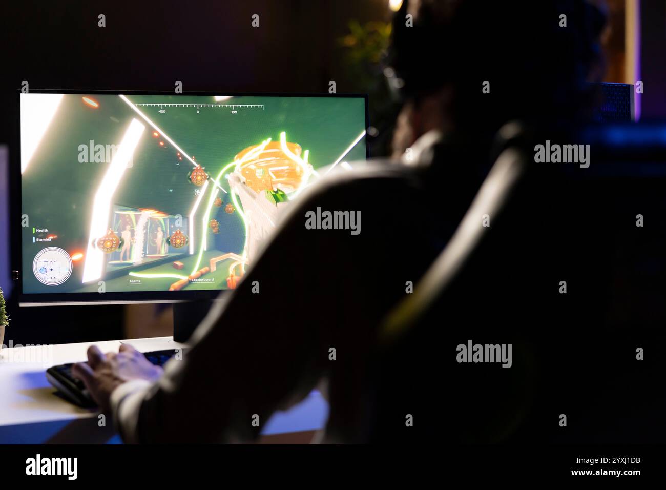 Man sitting on gaming chair, playing first person shooter videogame ...