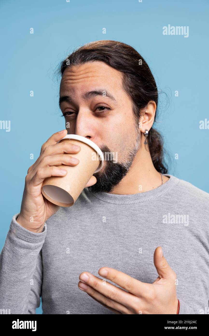 Middle eastern person sipping on black roast coffee cup in studio ...