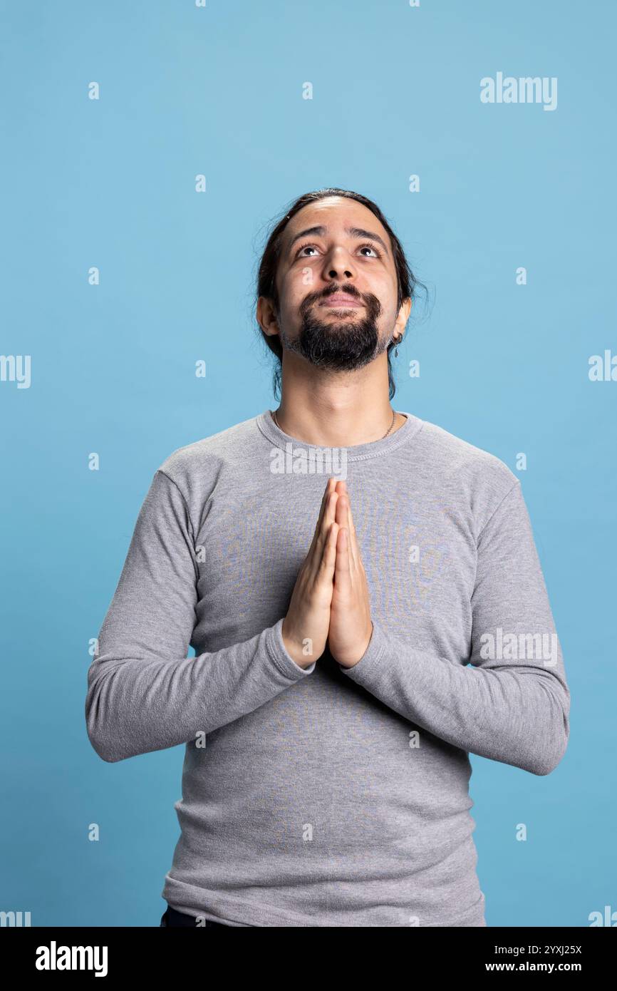 Male person posing with his hands in a prayer and worshipping God on ...