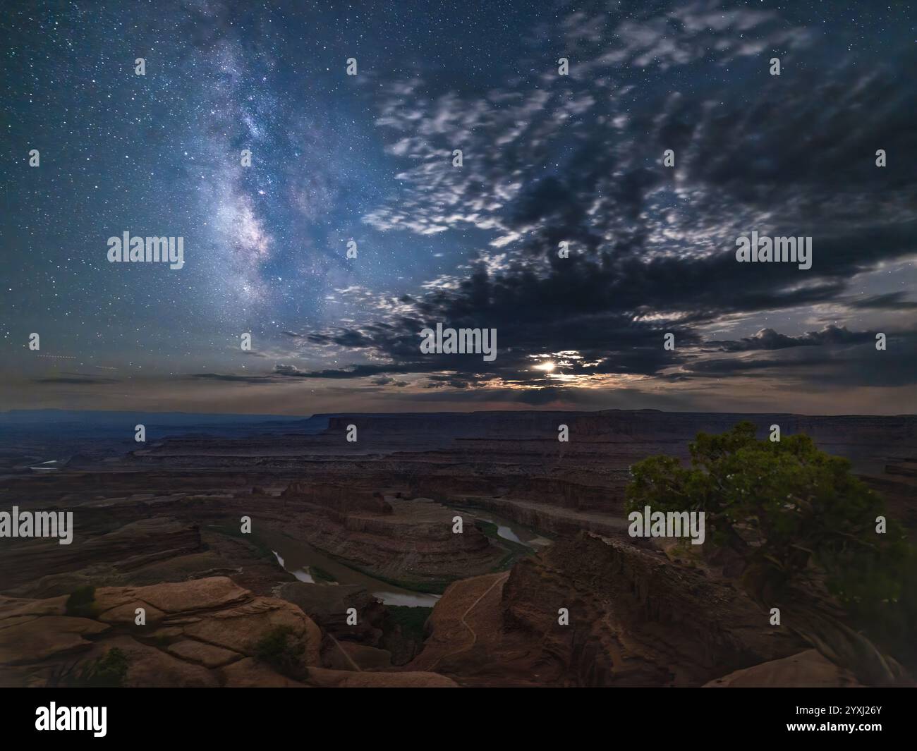 The Milky Way emerges from the clouds as the moon shines through above ...