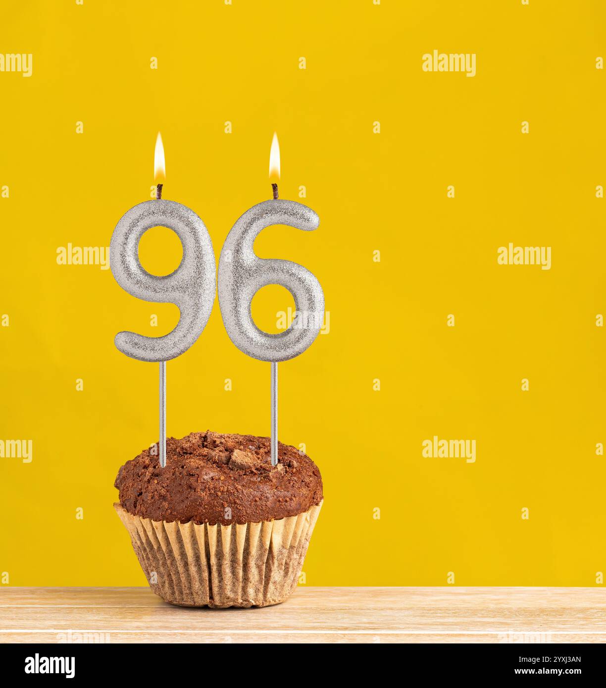Chocolate cupcake with number 96 candle - Birthday on a yellow ...