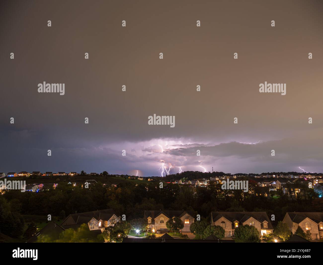 Dark storm clouds loom over an American neighborhood, with brilliant ...