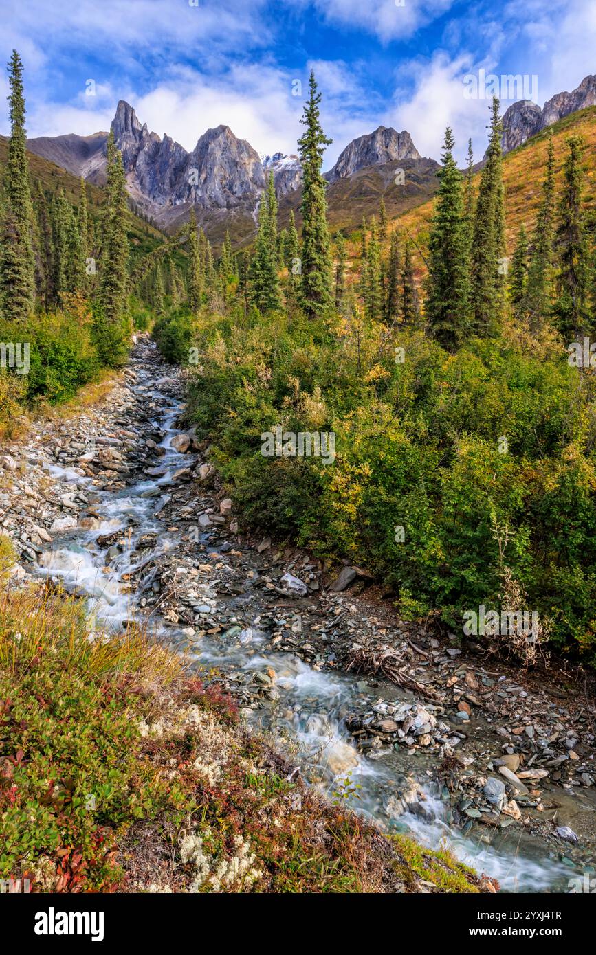A creek tumbles over rocks below the spires of Snowden Mountain in the ...