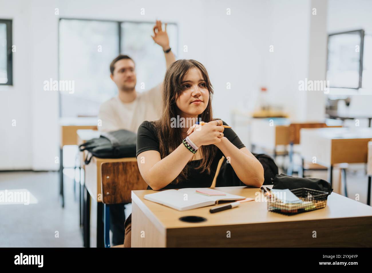 Attentive high school student participating in a classroom discussion ...