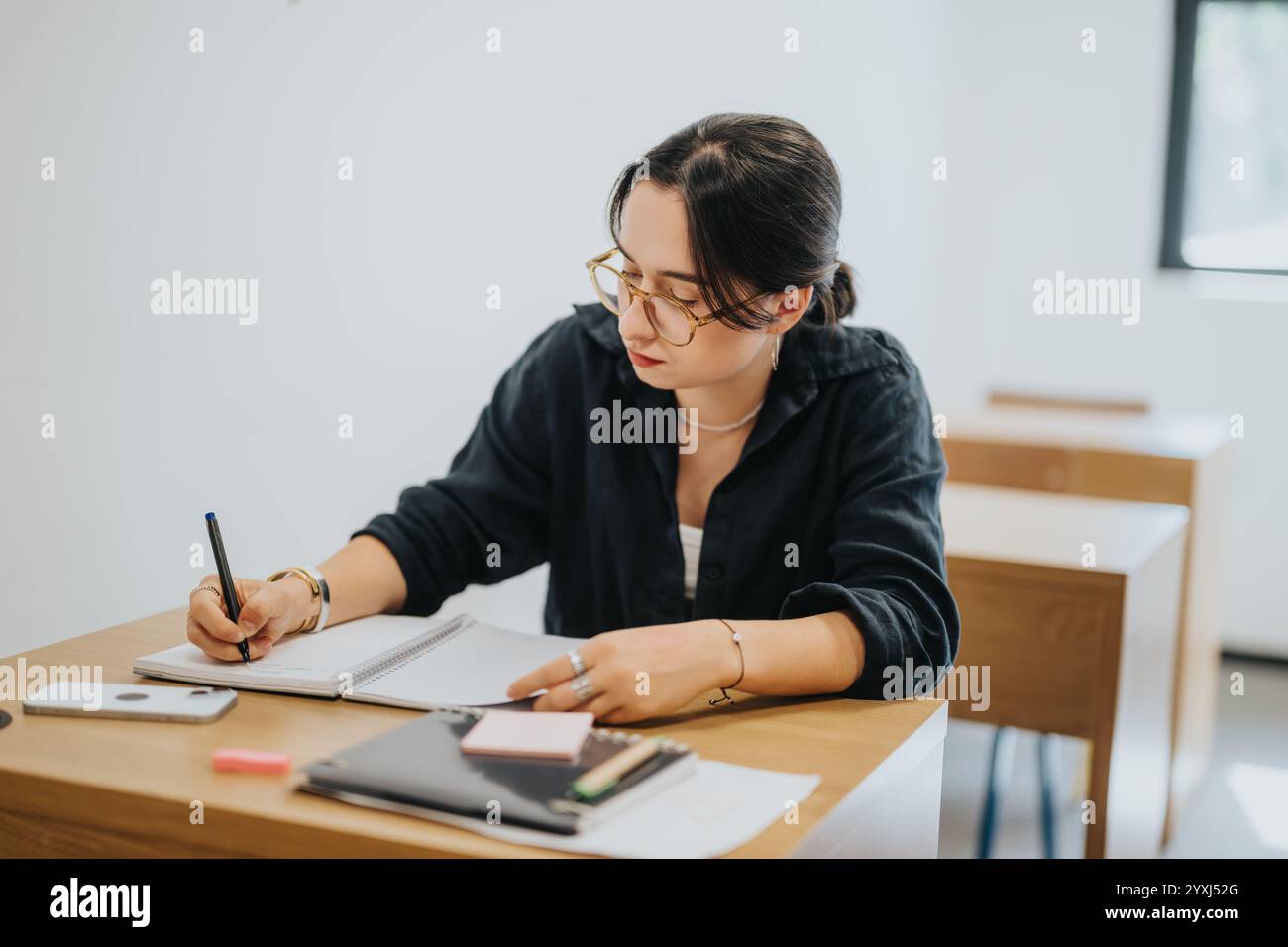 Focused high school student taking notes in classroom setting Stock ...