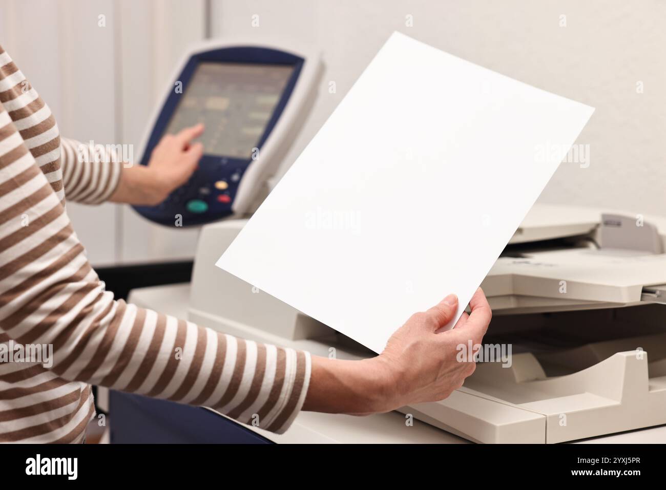 Woman with paper sheet using modern printer indoors, closeup. Printing ...