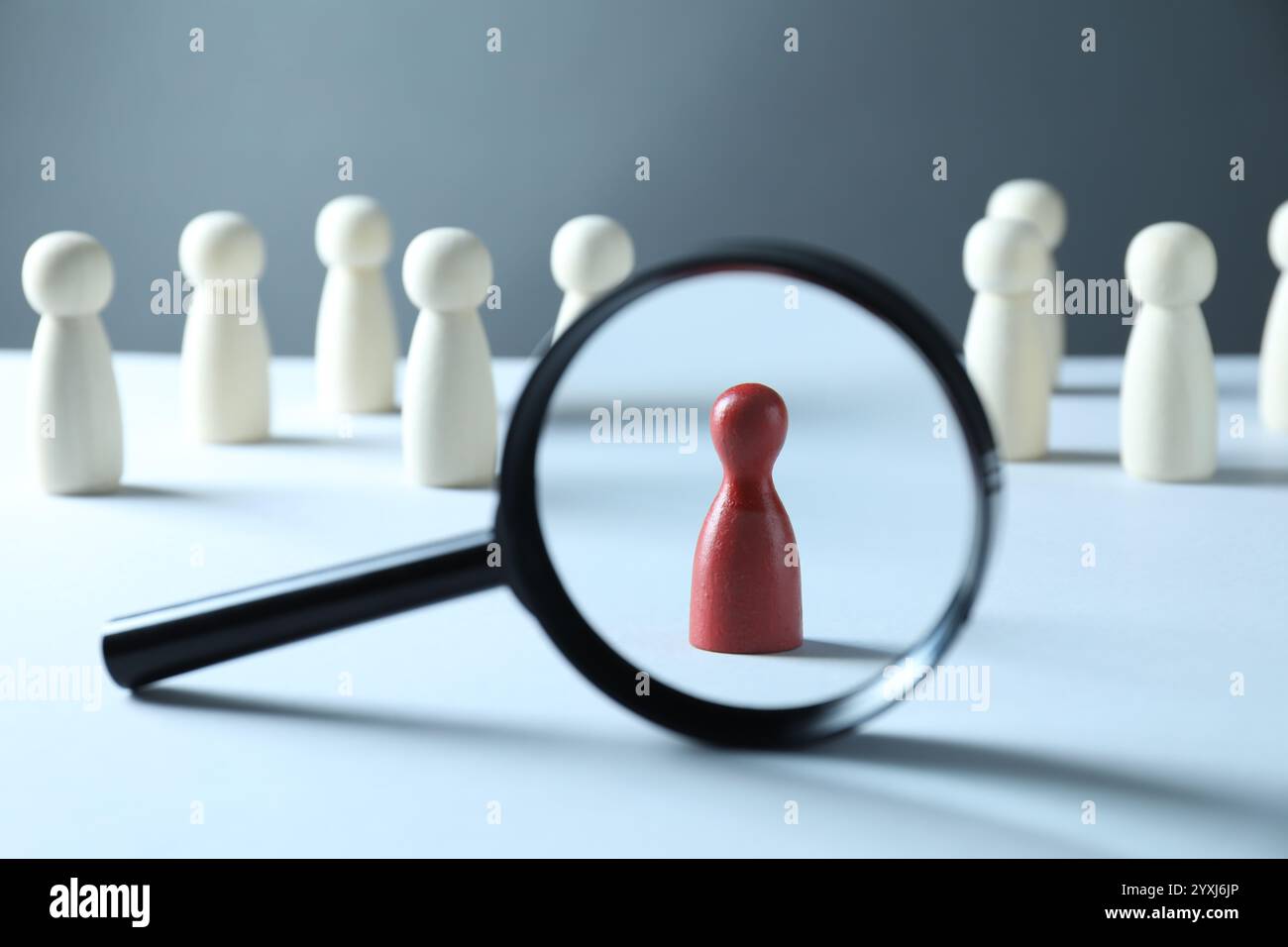 Human resources concept. Looking at red figure through magnifying glass ...