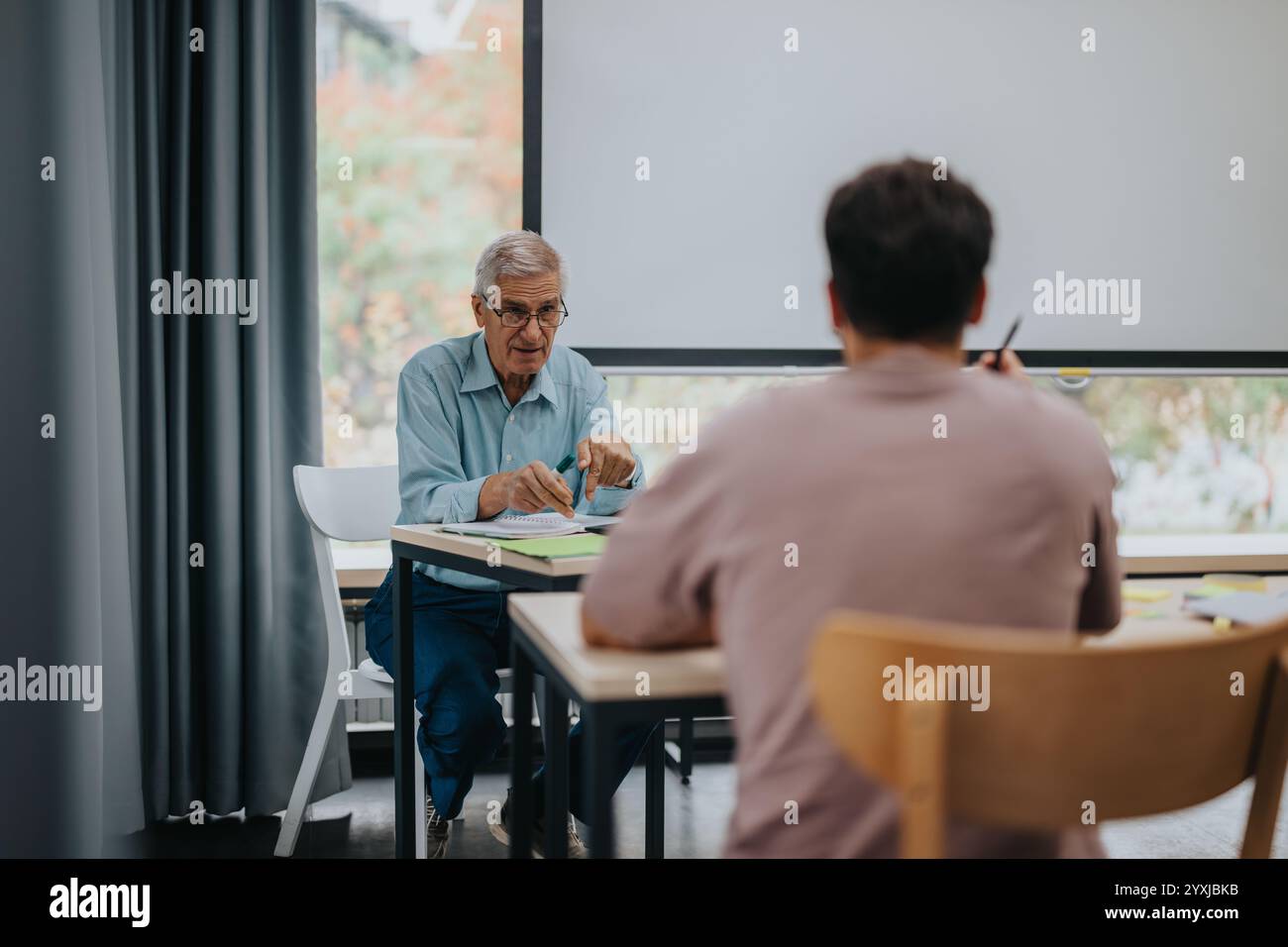 Elderly professor teaching students in a modern classroom setting Stock ...