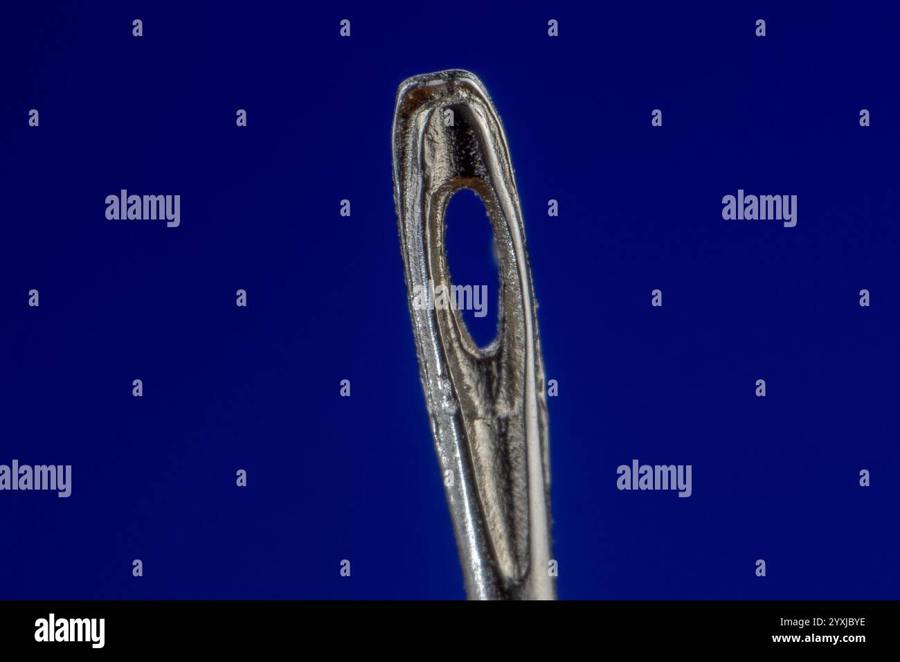Sewing needle eye in the center of the blue background image Stock ...