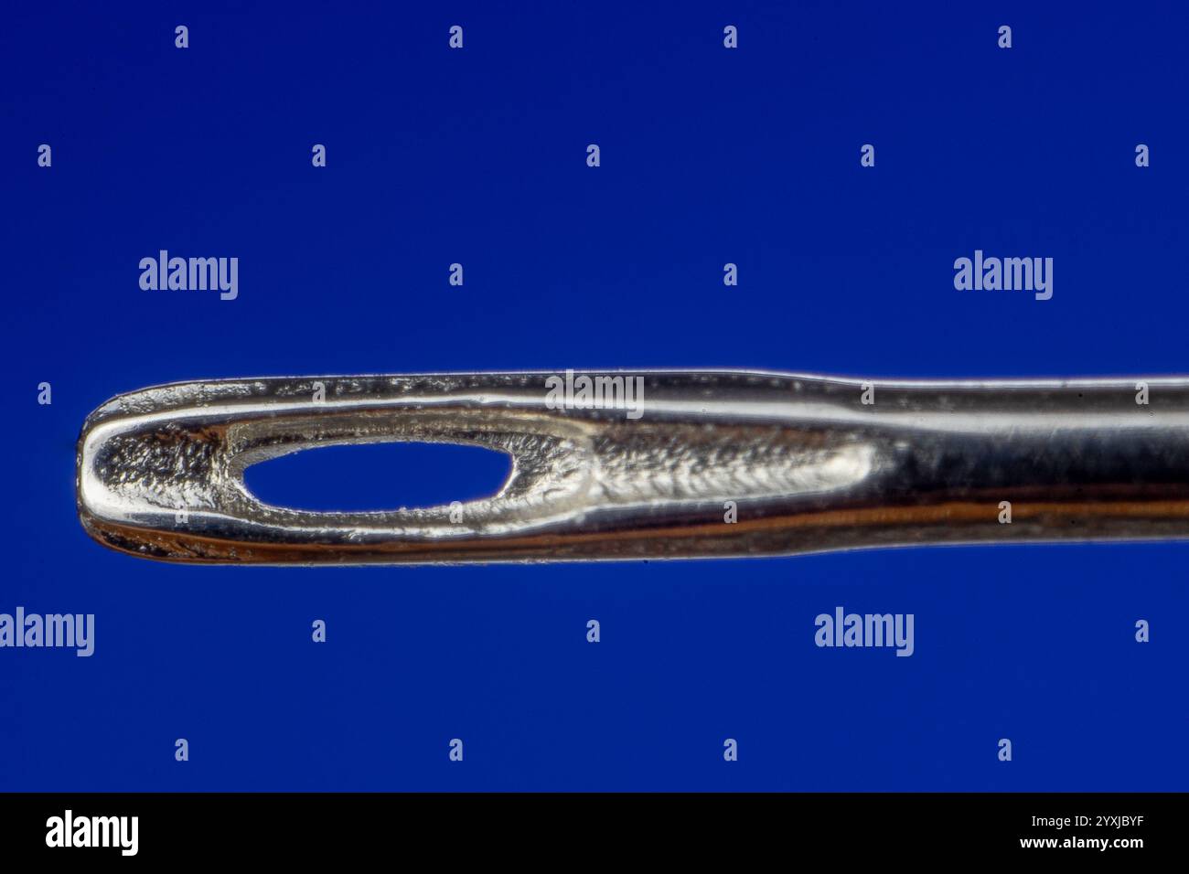 Sewing needle eye in the center of the blue background image Stock ...