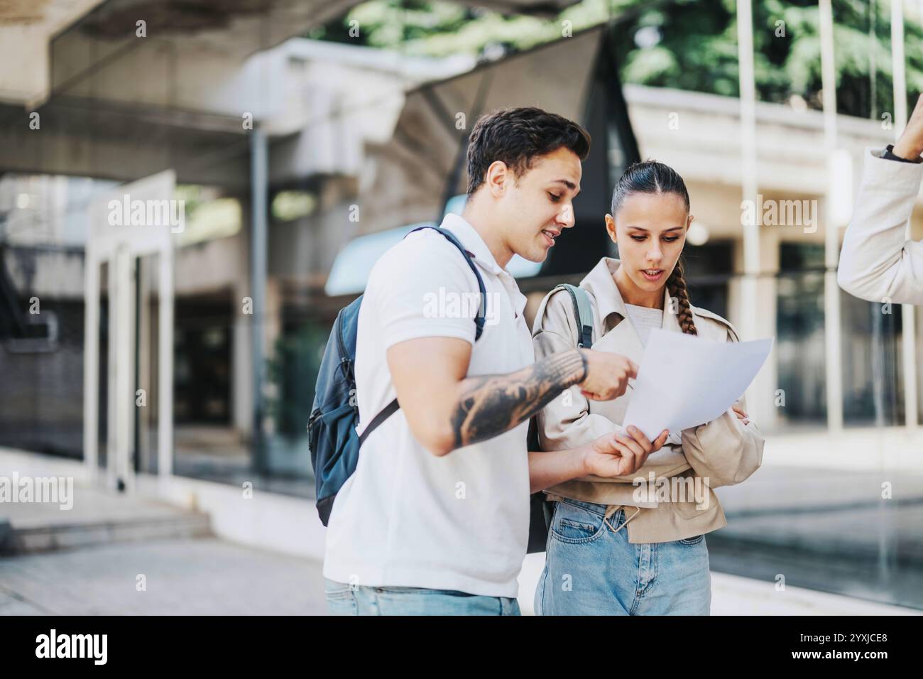 Students reviewing documents outdoors with a professor on campus Stock ...
