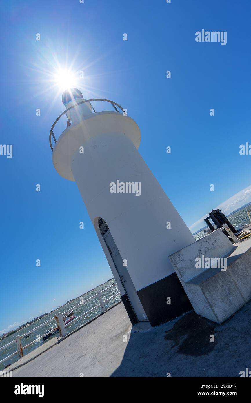 Lighthouse in diagonal frame with the sun at its top Stock Photo - Alamy