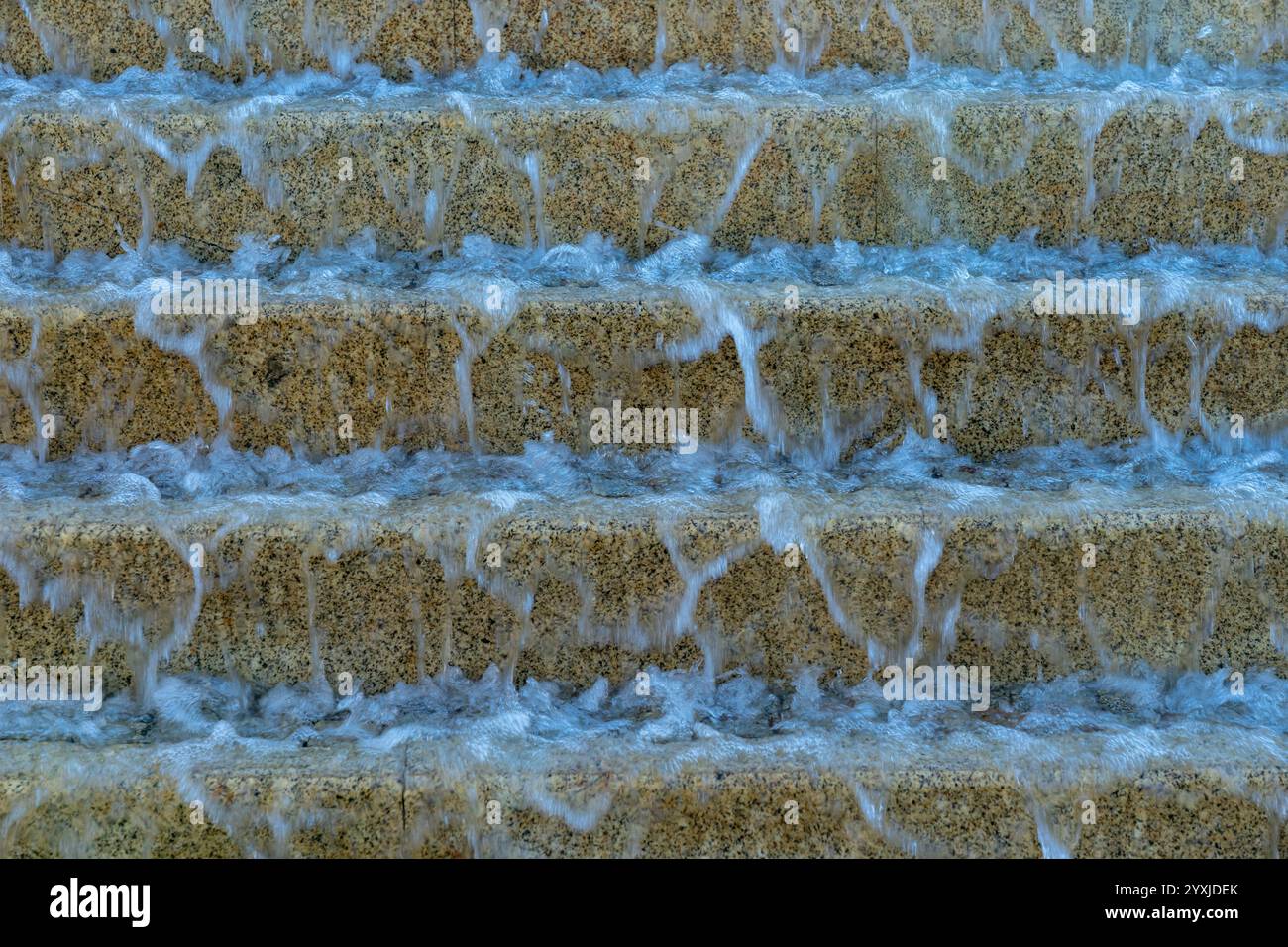 water running down stairs and forming foam passing through stone steps ...