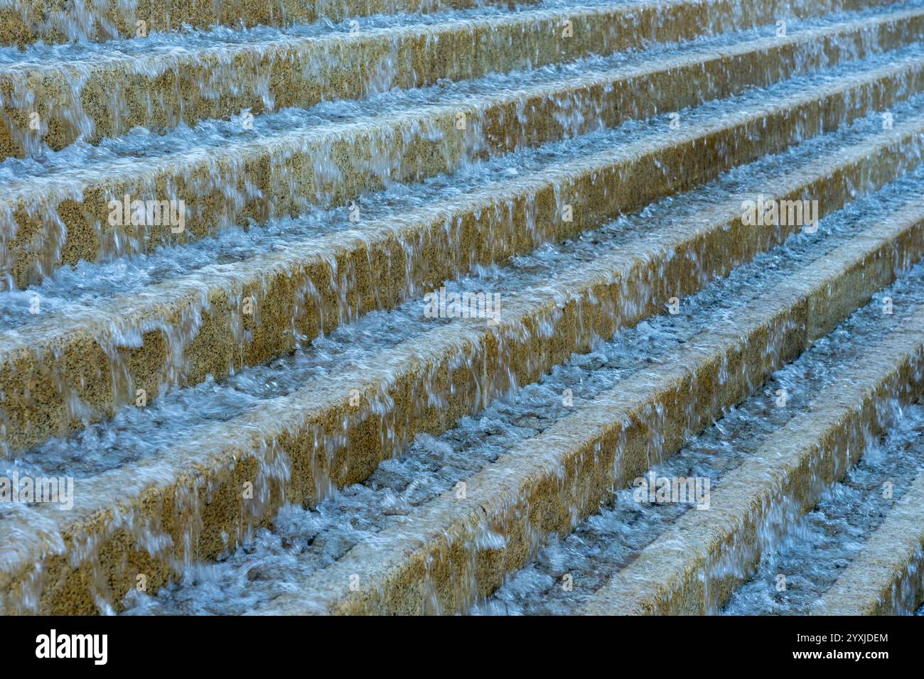 water running down stairs and forming foam passing through stone steps ...