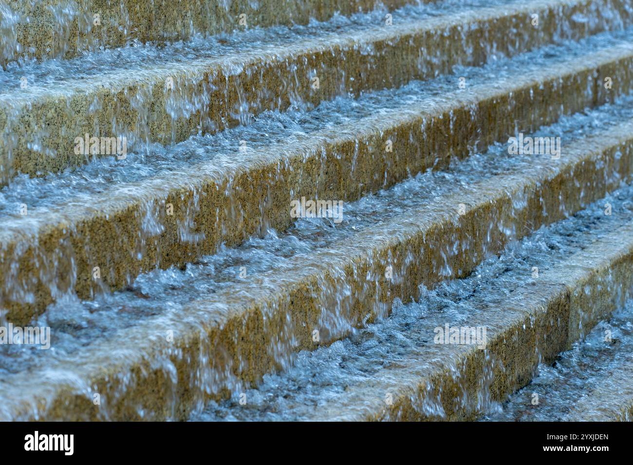 water running down stairs and forming foam passing through stone steps ...
