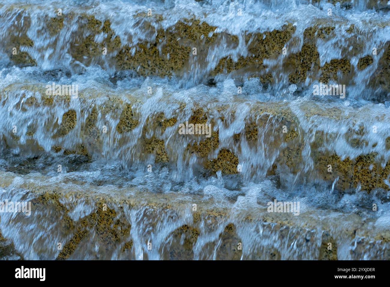 water running down stairs and forming foam passing through stone steps ...