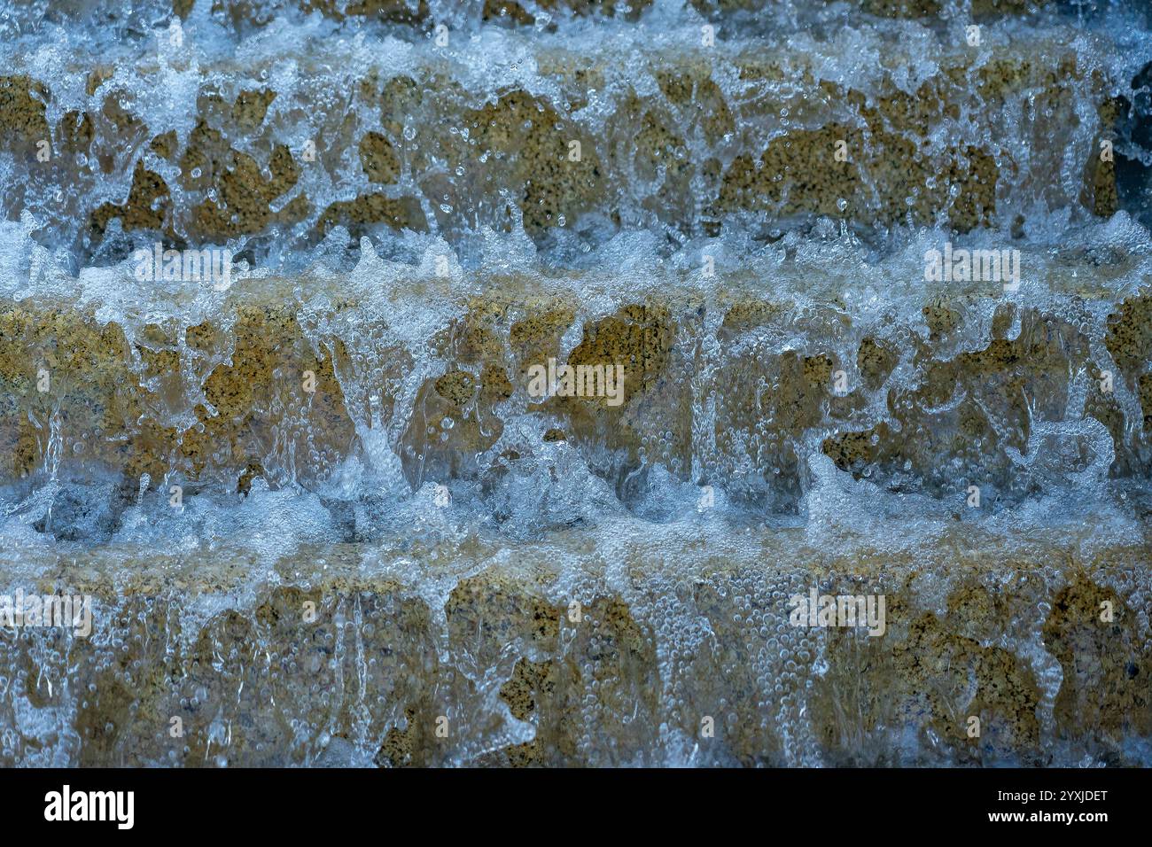 water running down stairs and forming foam passing through stone steps ...