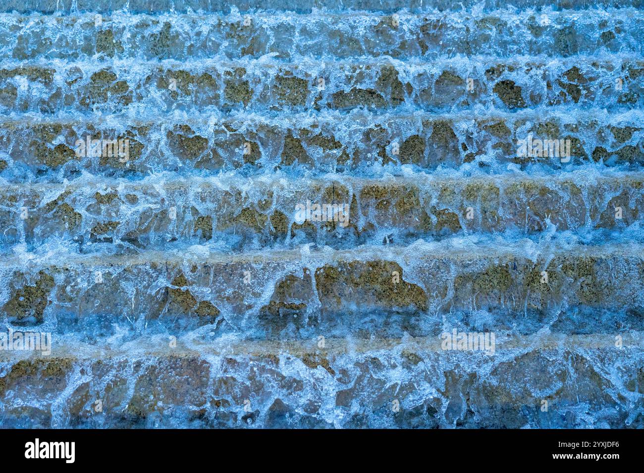 water running down stairs and forming foam passing through stone steps ...