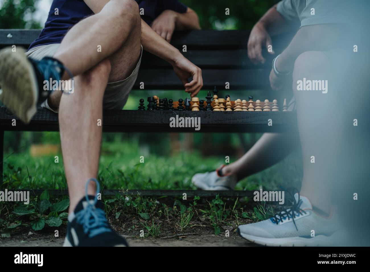 Two friends playing chess on a park bench in summer Stock Photo - Alamy
