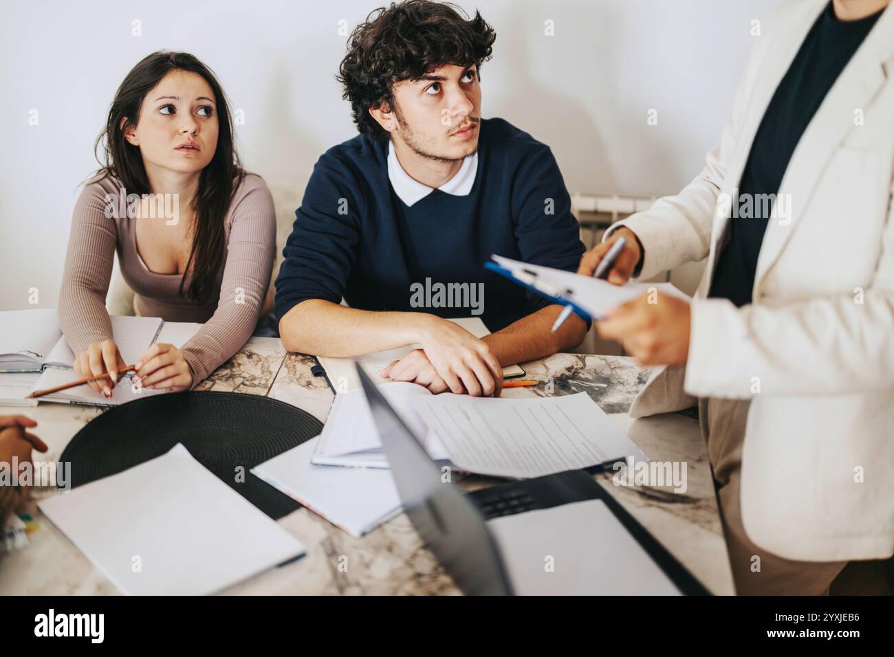College students engaged in home study session with paperwork Stock ...