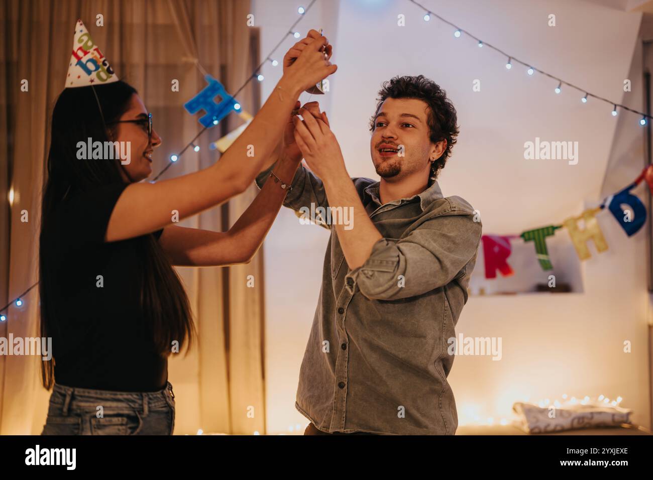 Friends joyfully celebrating a birthday at home with decorations Stock ...