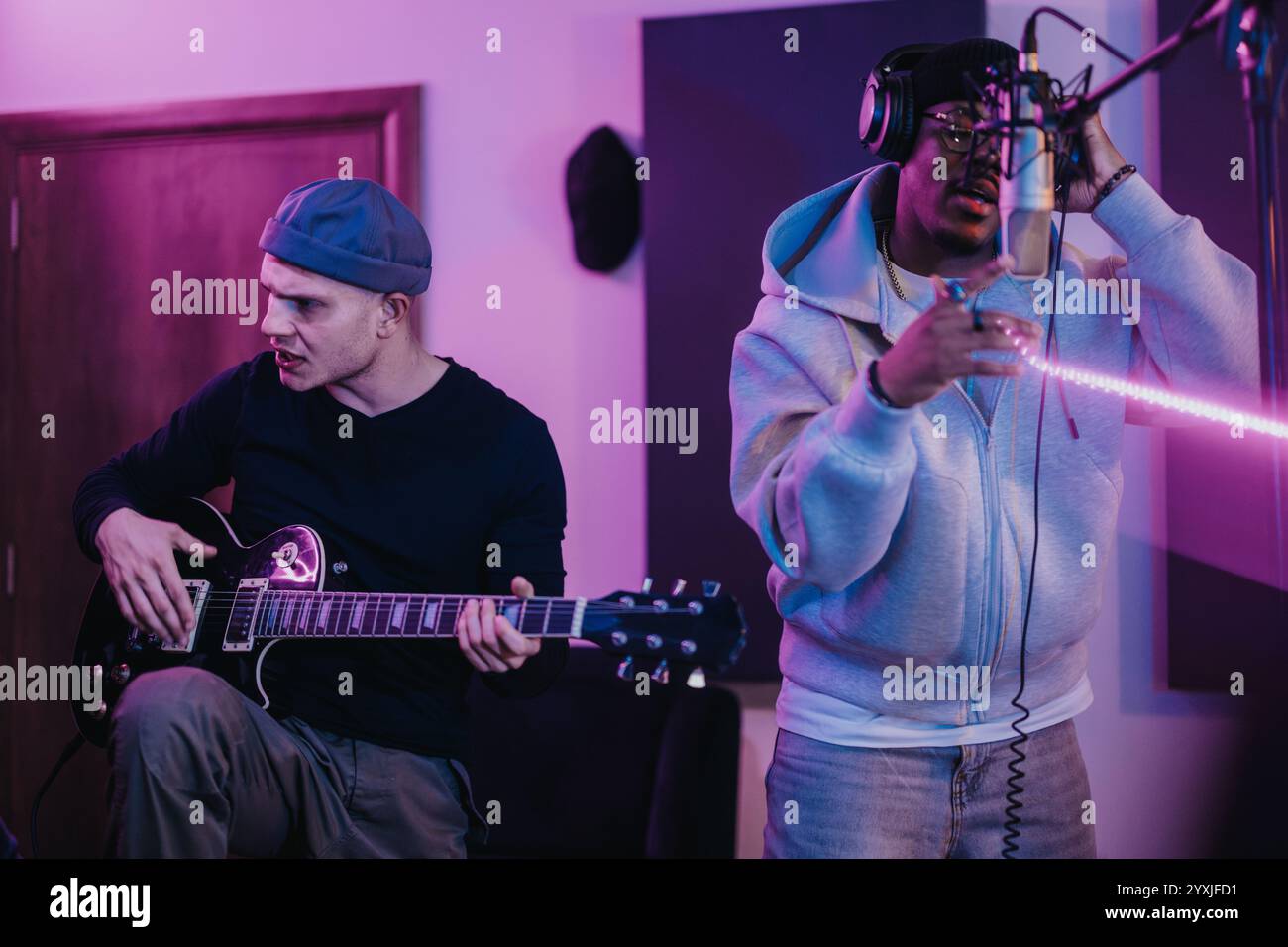 Musicians in a recording studio, one playing guitar and the other ...
