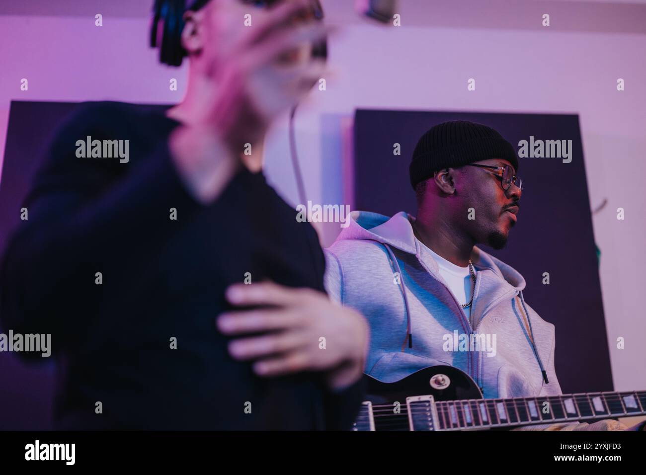 Two musicians collaborate in a studio focusing on creating new music ...