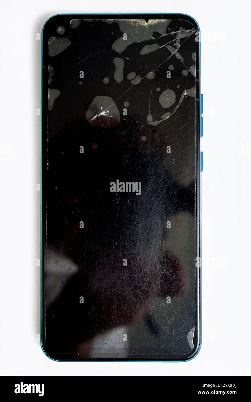 A heavily worn smartphone with a cracked and dirty screen is displayed ...