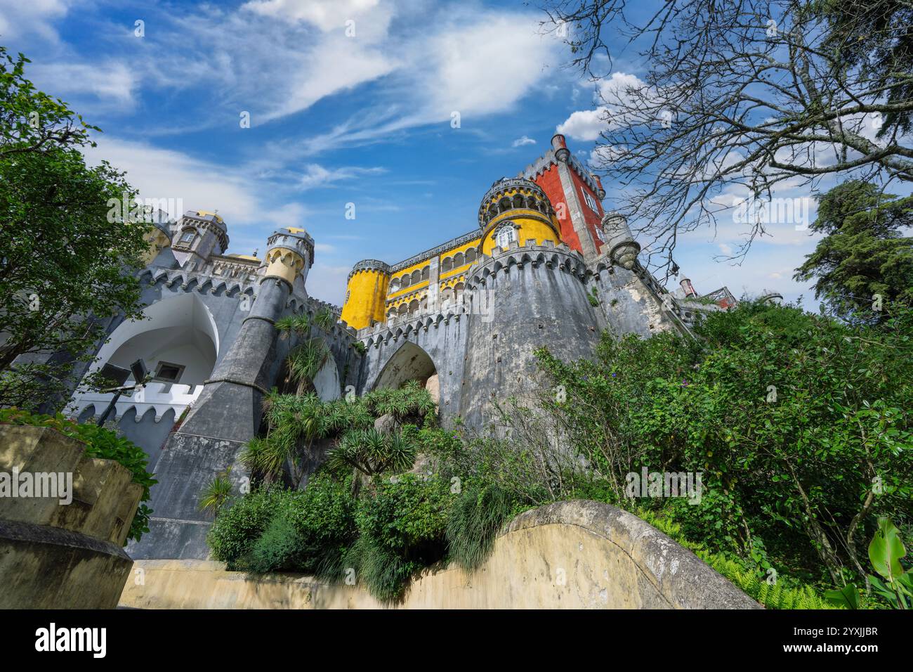 The Pena Palace showcases its vibrant yellow and red towers against a ...