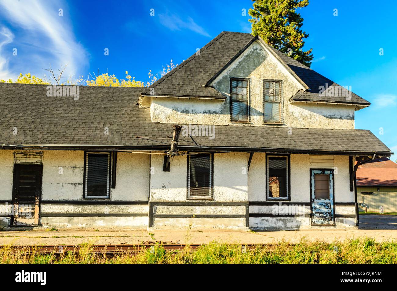 The old house has a lot of windows and a black roof. The house is empty ...