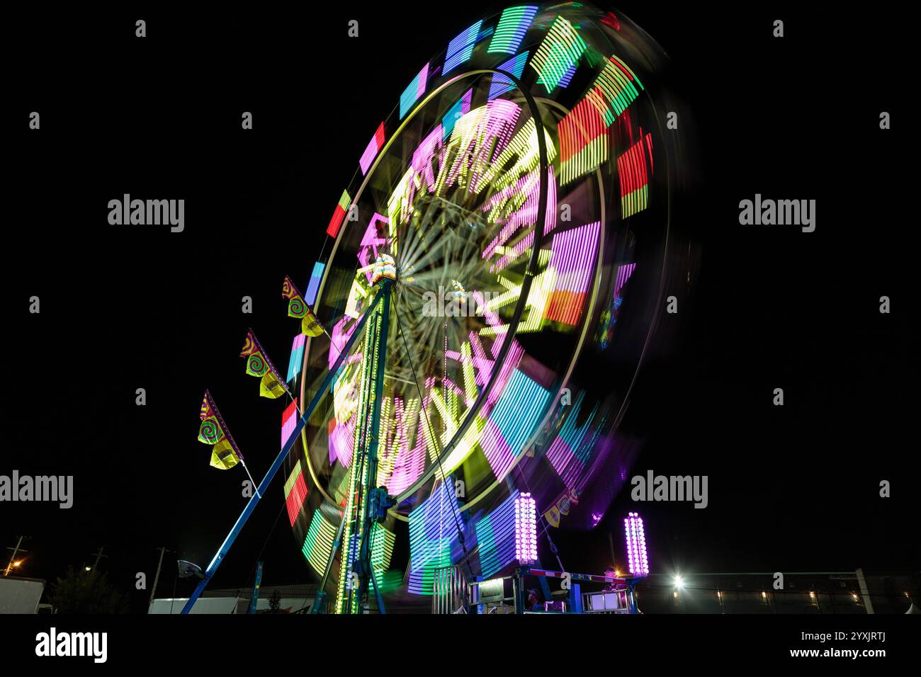 A colorful merry go round with lights on it. The lights are bright and ...