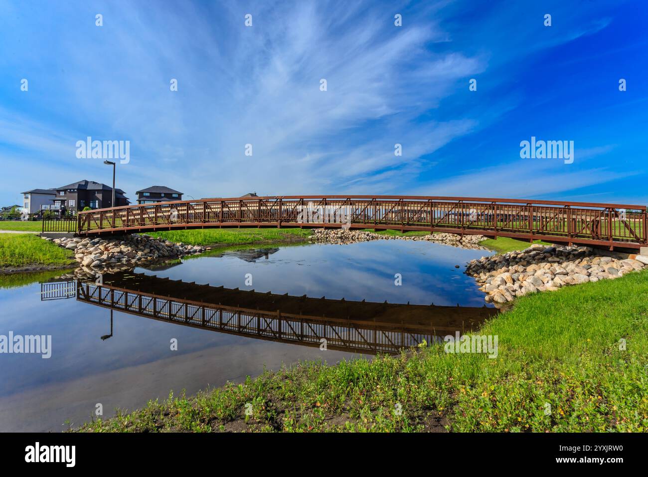 A bridge spans a body of water, with a reflection of the bridge in the ...