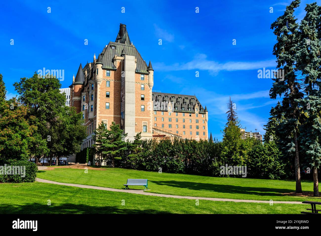 A large brick building with a green roof sits in a grassy field. The ...