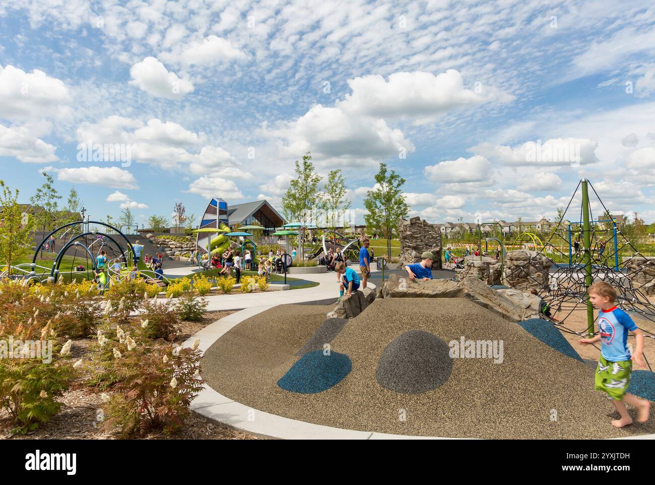 Kids playing on rubber surfaced hill in playground hi-res stock ...
