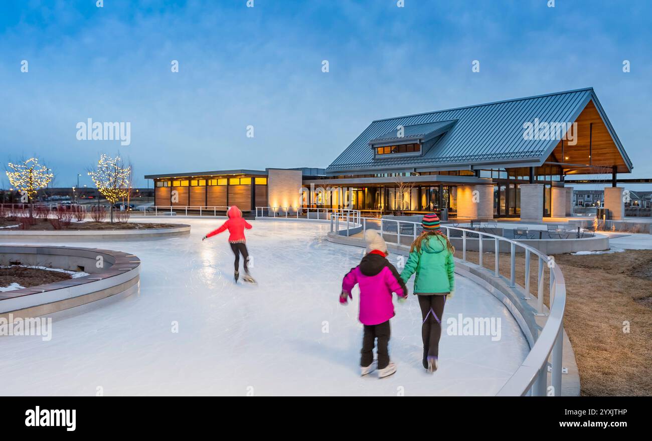 Ice skaters on ice skating track with modern warming house in ...