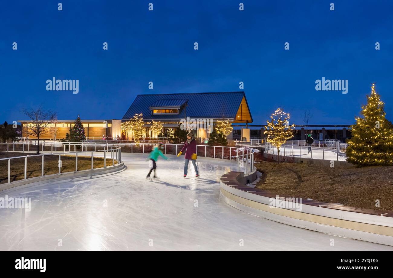 Ice skaters on ice skating track with modern warming house in ...