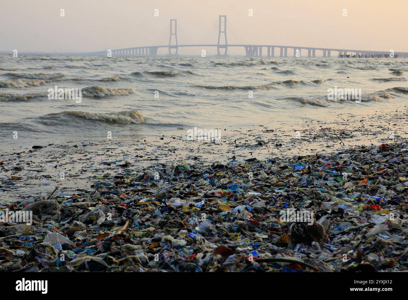 A wave of garbage in the waters near the Suramadu Bridge that connects ...