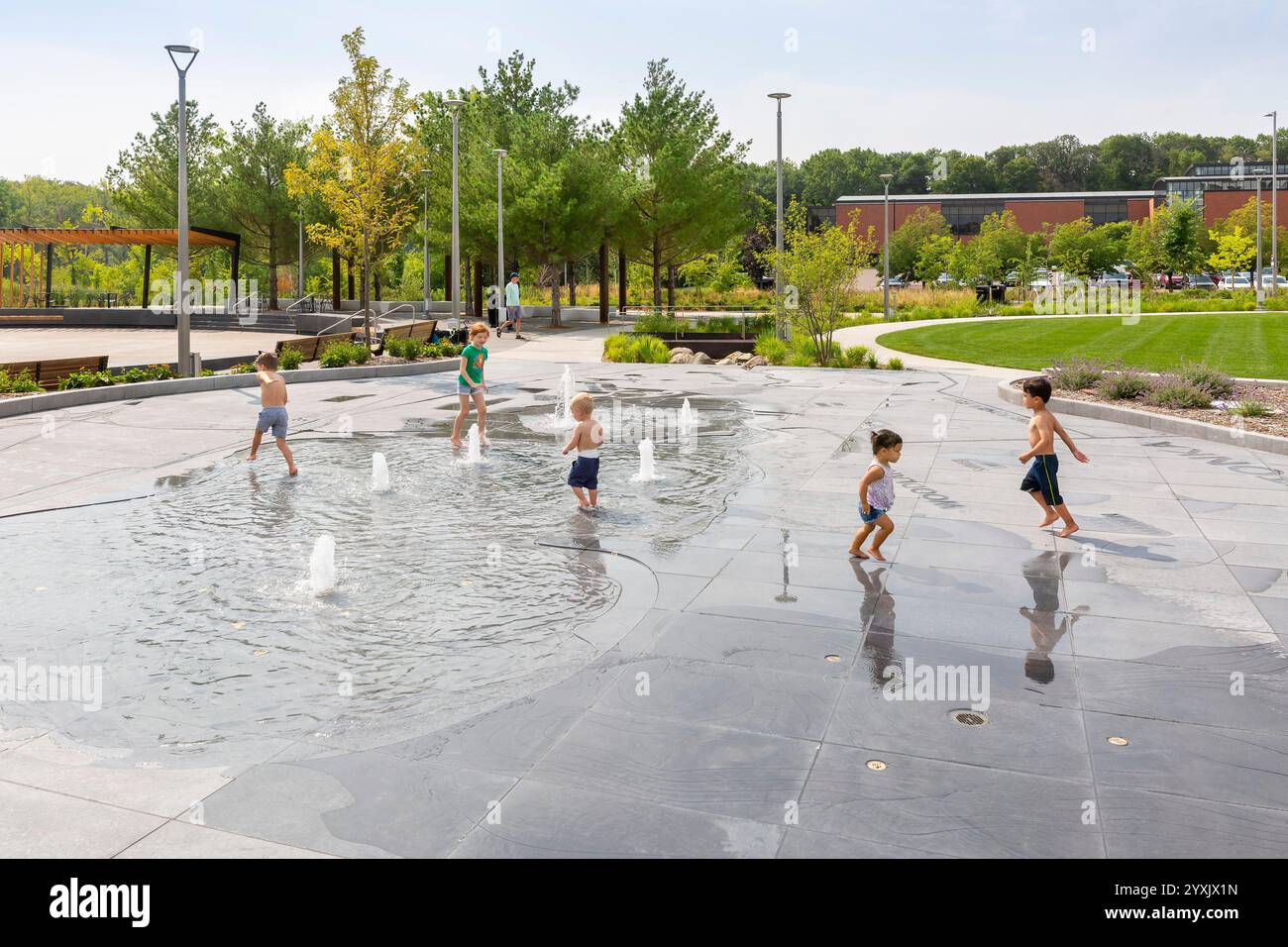 Children playing on a splash pad for an interactive water feature at a public park Stock Photo ...