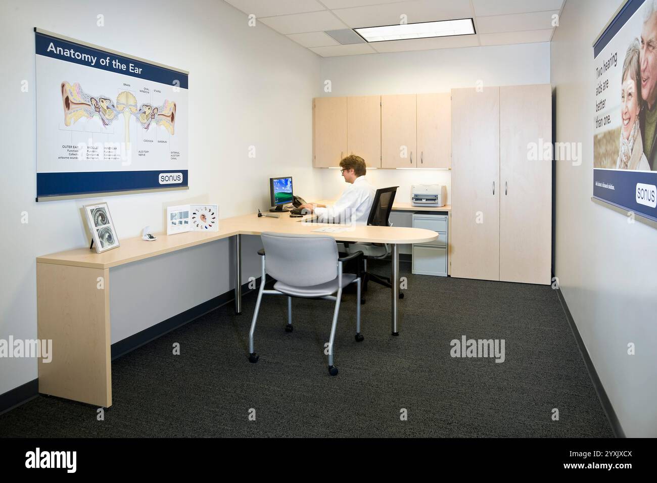 Office space of audiologist with doctor at computer Stock Photo - Alamy