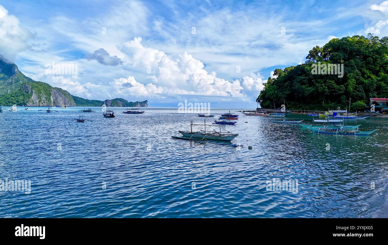 A peaceful tropical bay in the Philippines featuring traditional boats ...