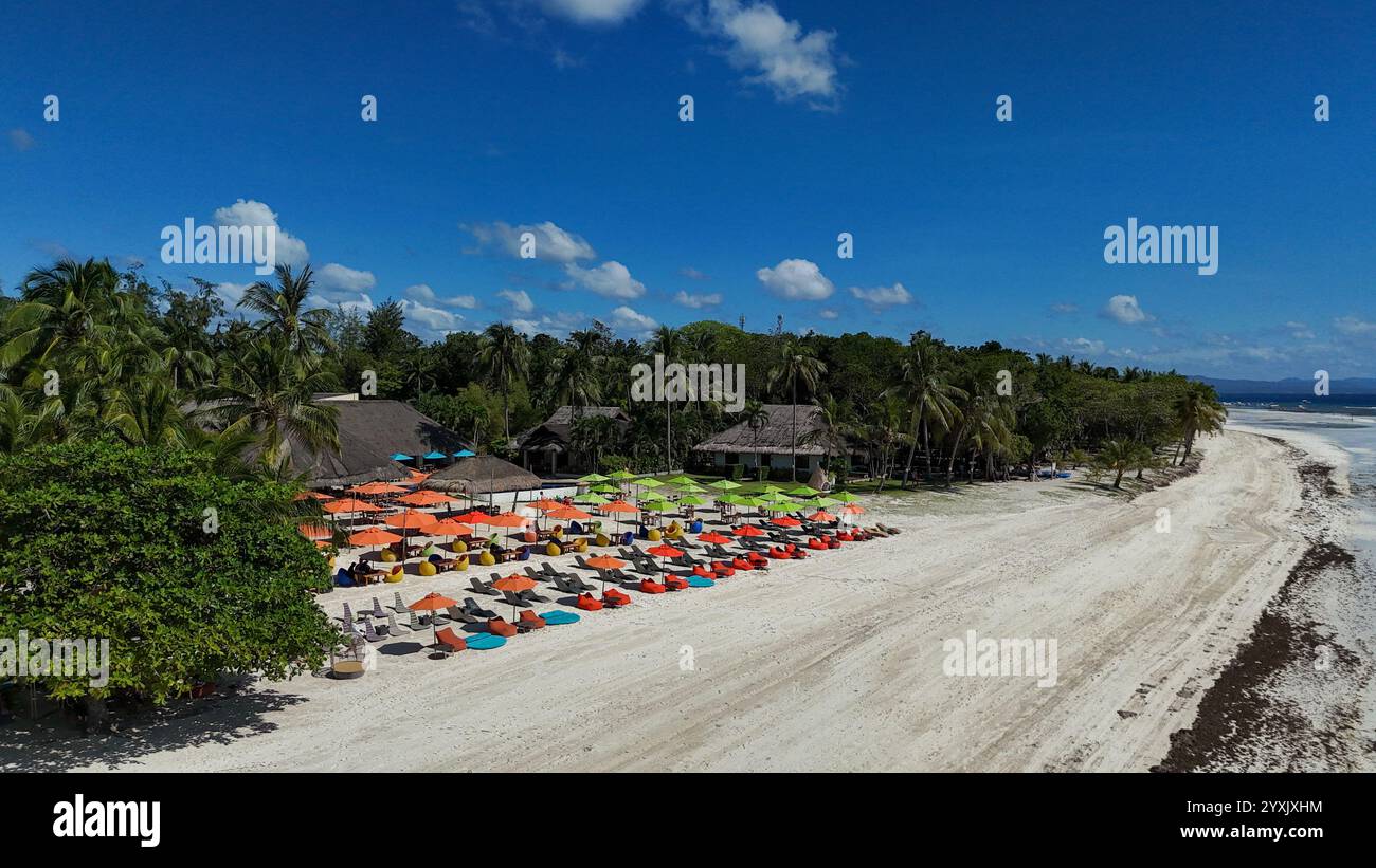 An aerial view of a vibrant beach resort featuring colorful umbrellas ...