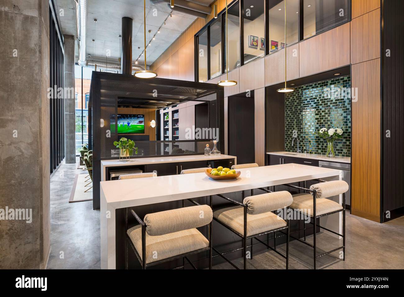 Two story lobby of apartment building showing small bar and kitchen ...