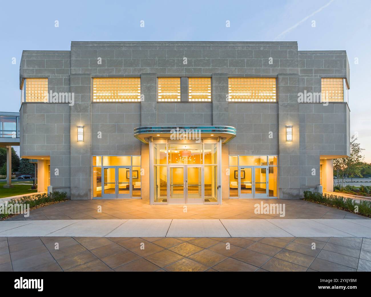 Exterior of art deco building at dusk with lights on Stock Photo - Alamy
