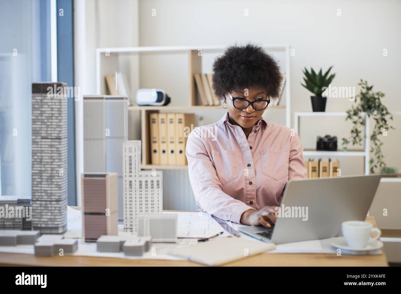 African woman architect working on laptop to design modern city model ...