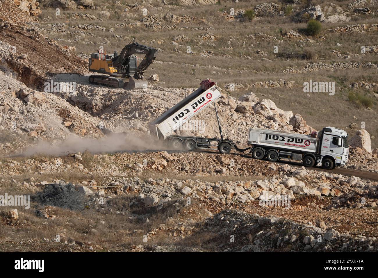 Israeli trucks work making a road inside the buffer zone near the so ...